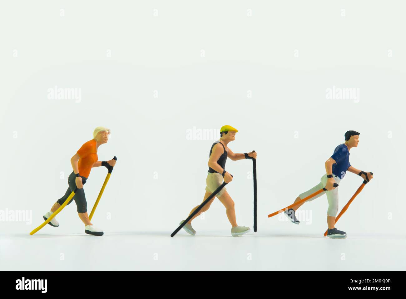 The miniature figures of hikers walking holding sticks in both hands on ...