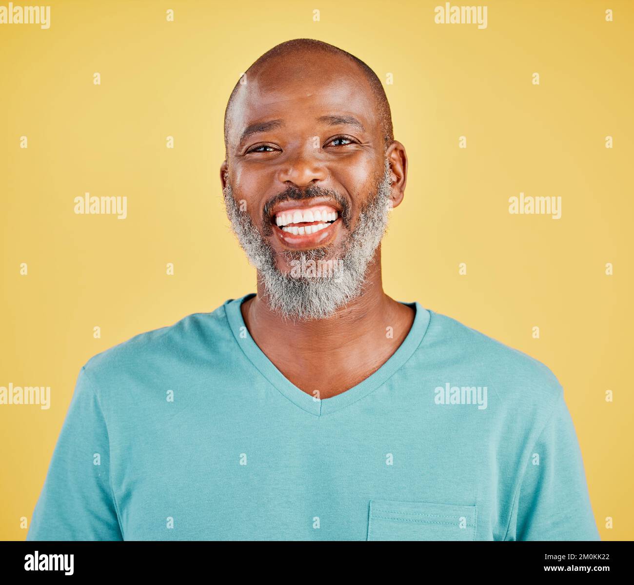Mature african man laughing out loud against a yellow studio background ...