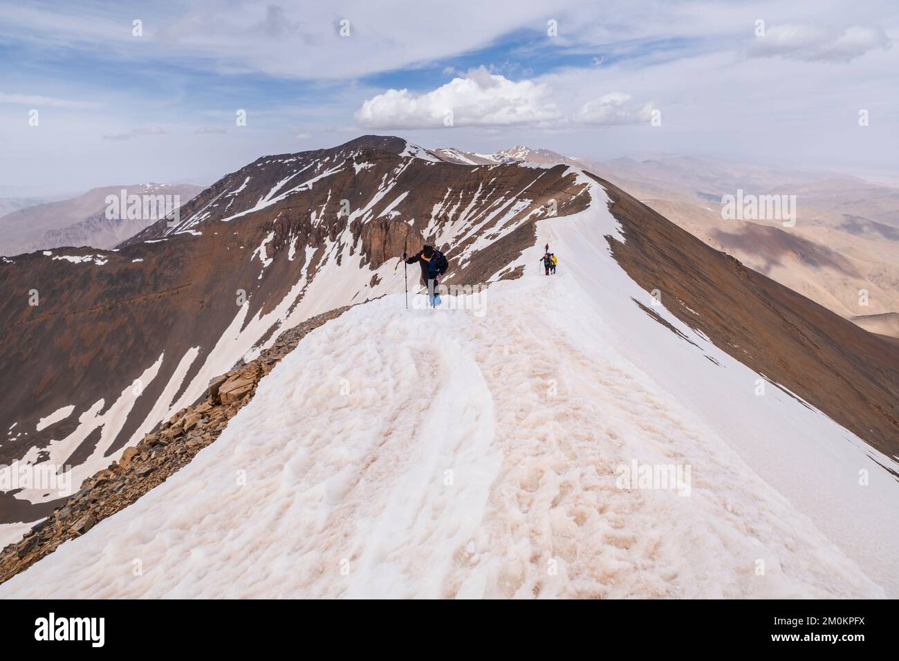 mountaineers on the ridge reaching the top Ighil M'Goun, 4,071 meters ...