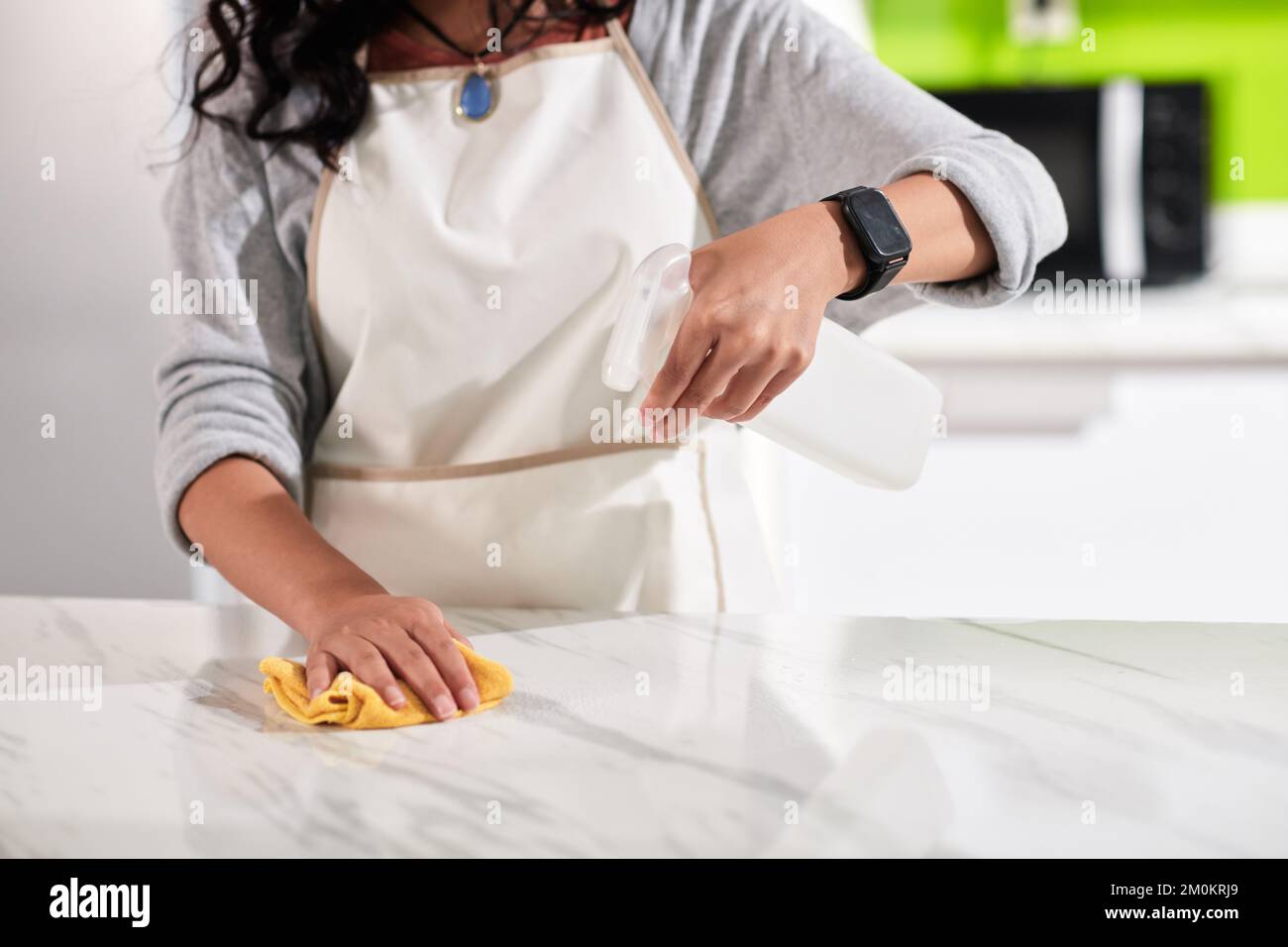 Housewife wiping kitchen counter with cleaning detergent and soft cloth ...