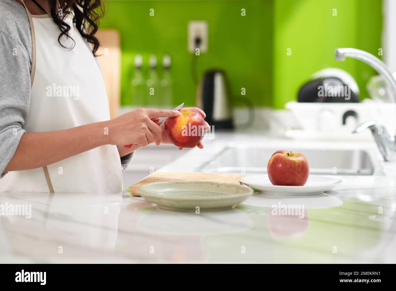 Hands of woman peeling red apple when making pie for dessert Stock ...