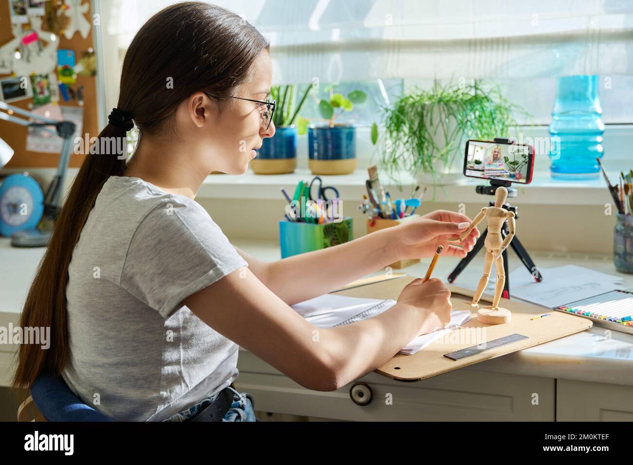 Teenage girl drawing sketch, looking at screen of smartphone Stock ...