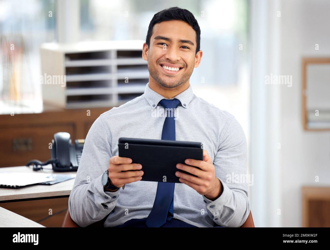Young happy mixed race businessman holding and using a digital tablet ...