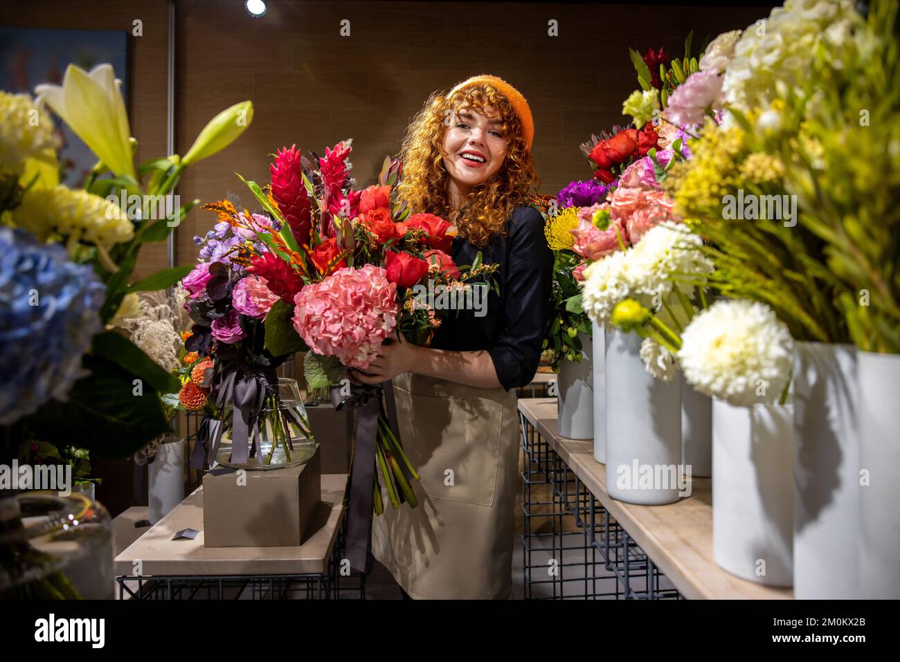 Smiling pretty young woman in a flower shop Stock Photo - Alamy