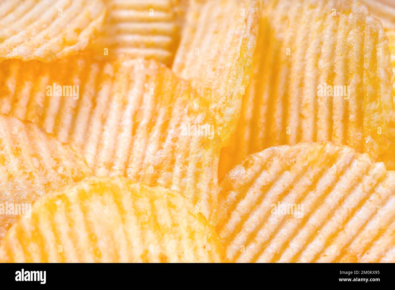 Yellow crispy ridged potato chips close up. Food background, banner ...