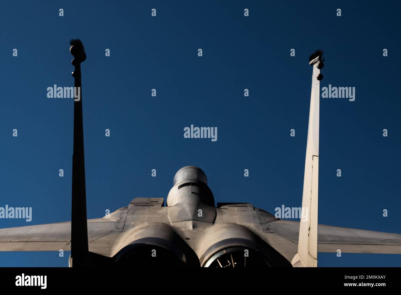 A closeup of rear of military supersonic jet F-15 eagle blue sky ...