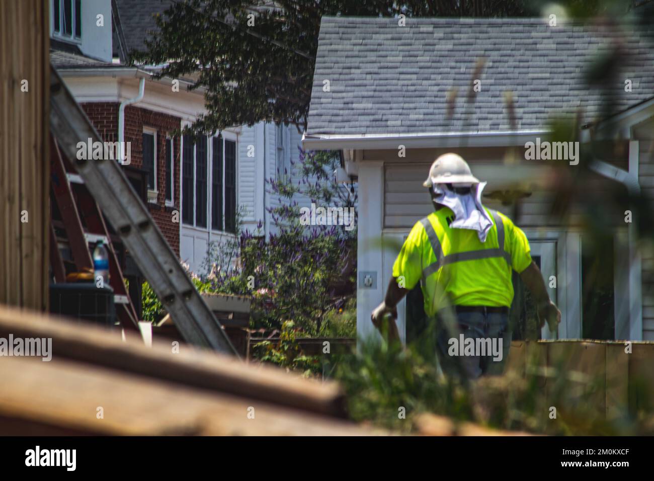 A rear of a construction worker surrounded by storm damage from the ...