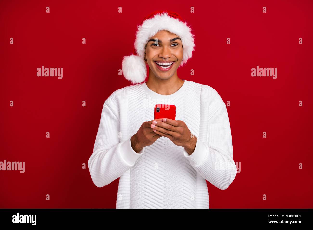 Photo of handsome excited guy toothy smile hands hold use telephone ...