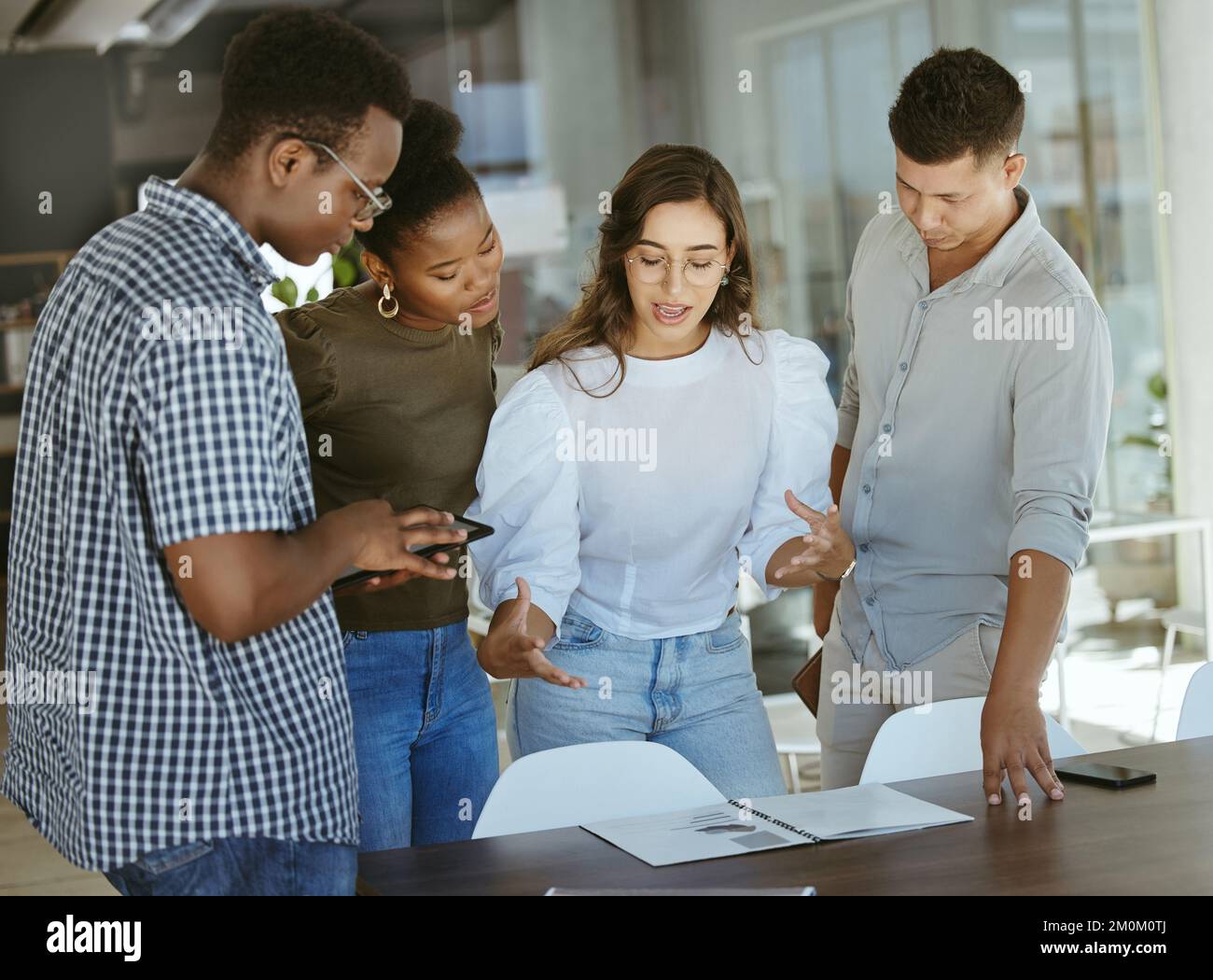 Group of focused businesspeople standing and talking together in an ...