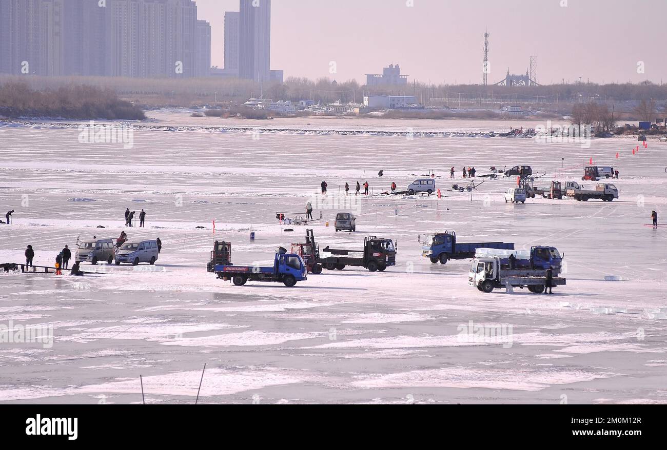 Aerial photo shows workers are busy cutting and mining ice on the ...