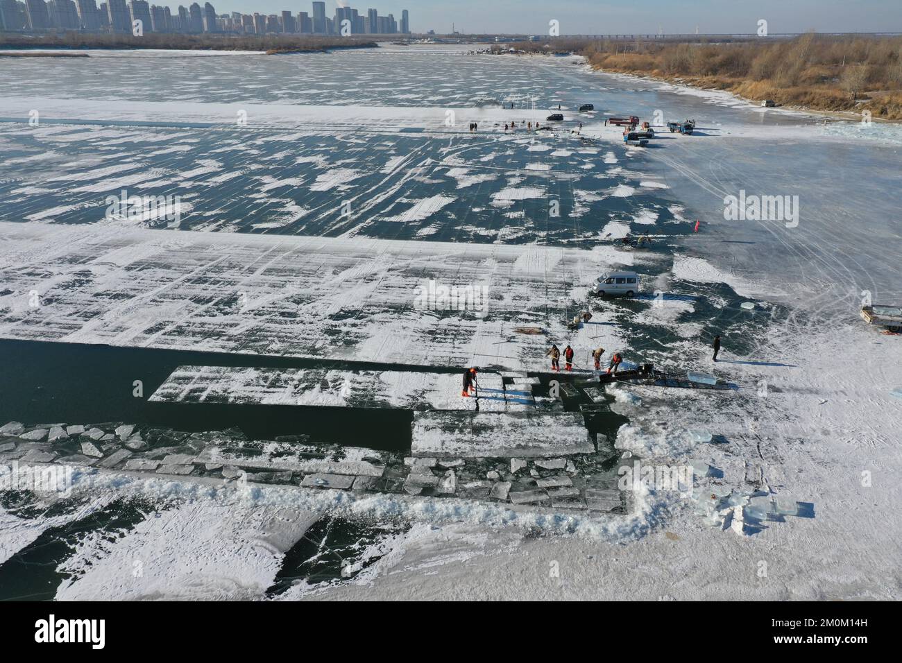Aerial photo shows workers are busy cutting and mining ice on the ...