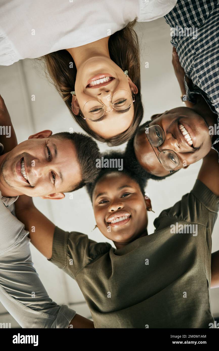 Team of creatives huddled together in unity. Happy diverse business ...