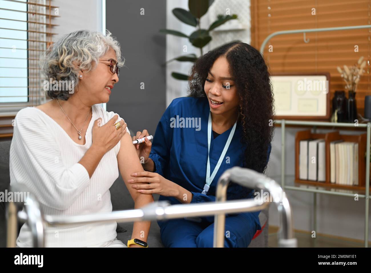 Female nurse gives a dose of insulin to diabetic senior woman during ...