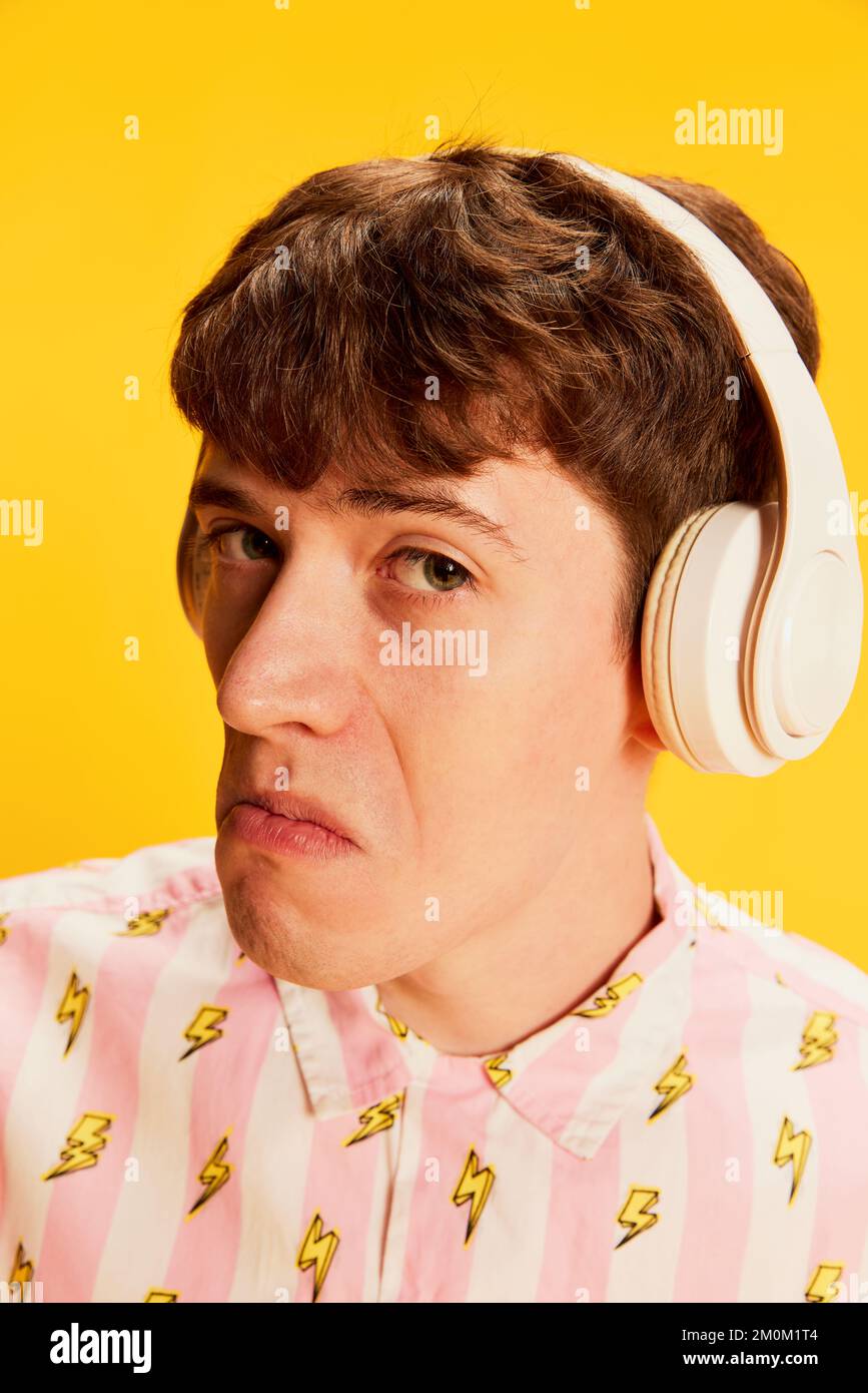 Closeup portrait of emotive young man in headphones listening to music ...