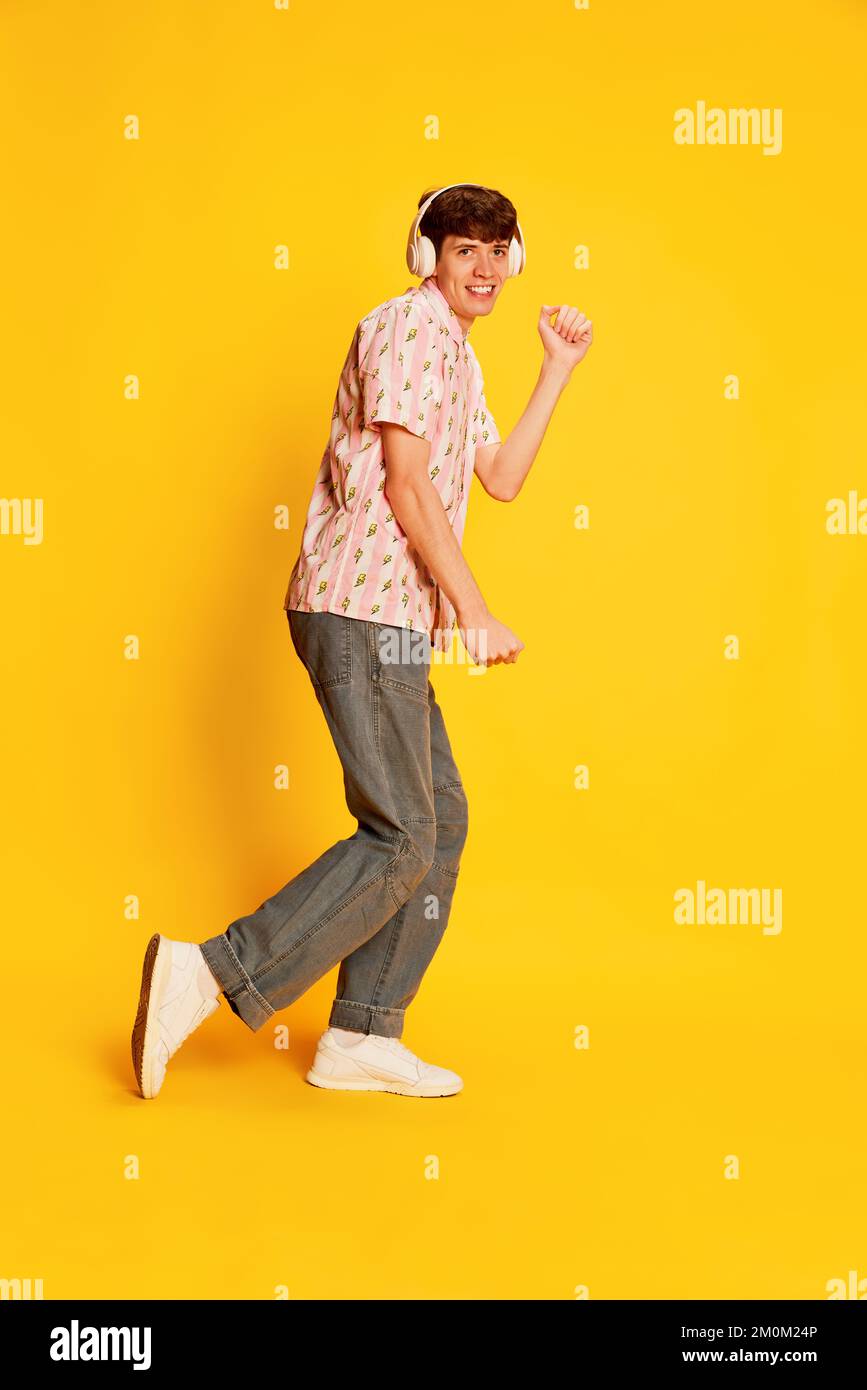 Emotional smiling man, student in headphones listening to music and ...