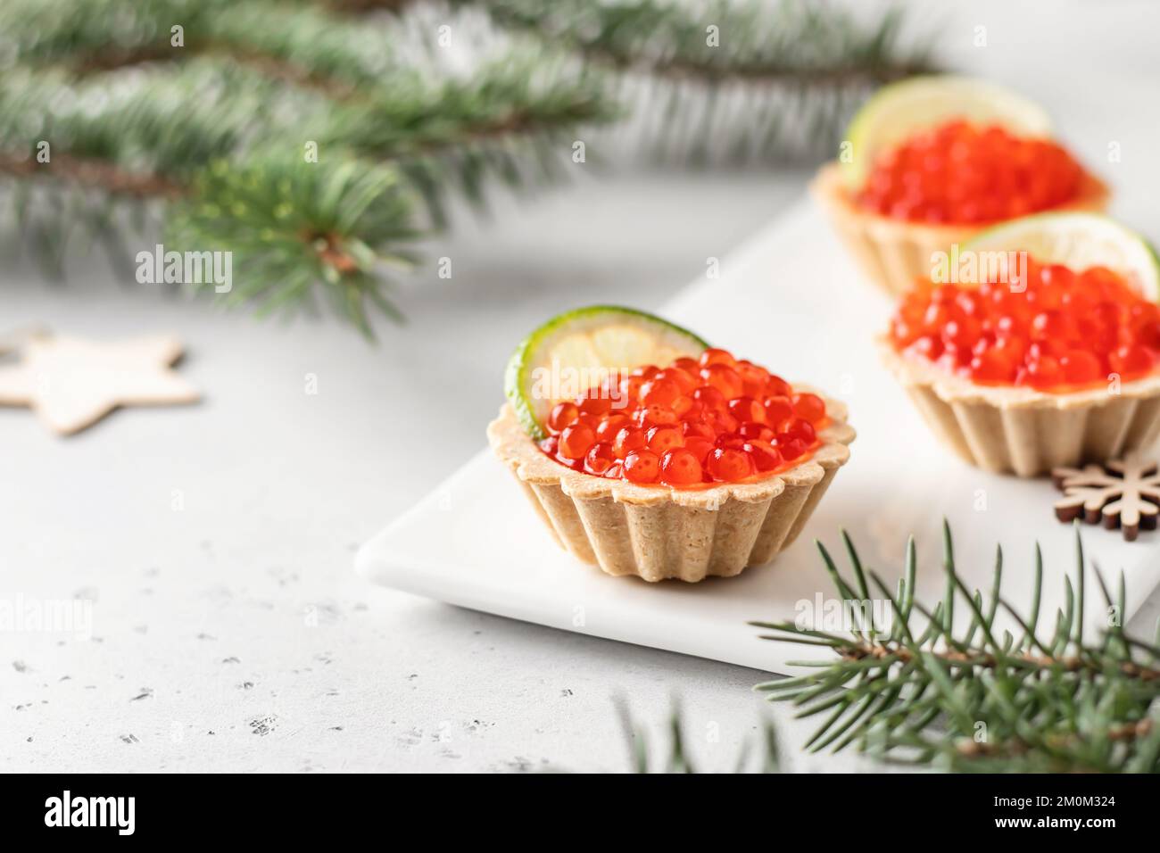 Festive Christmas appetizer tartlets stuffed with red caviar and a ...
