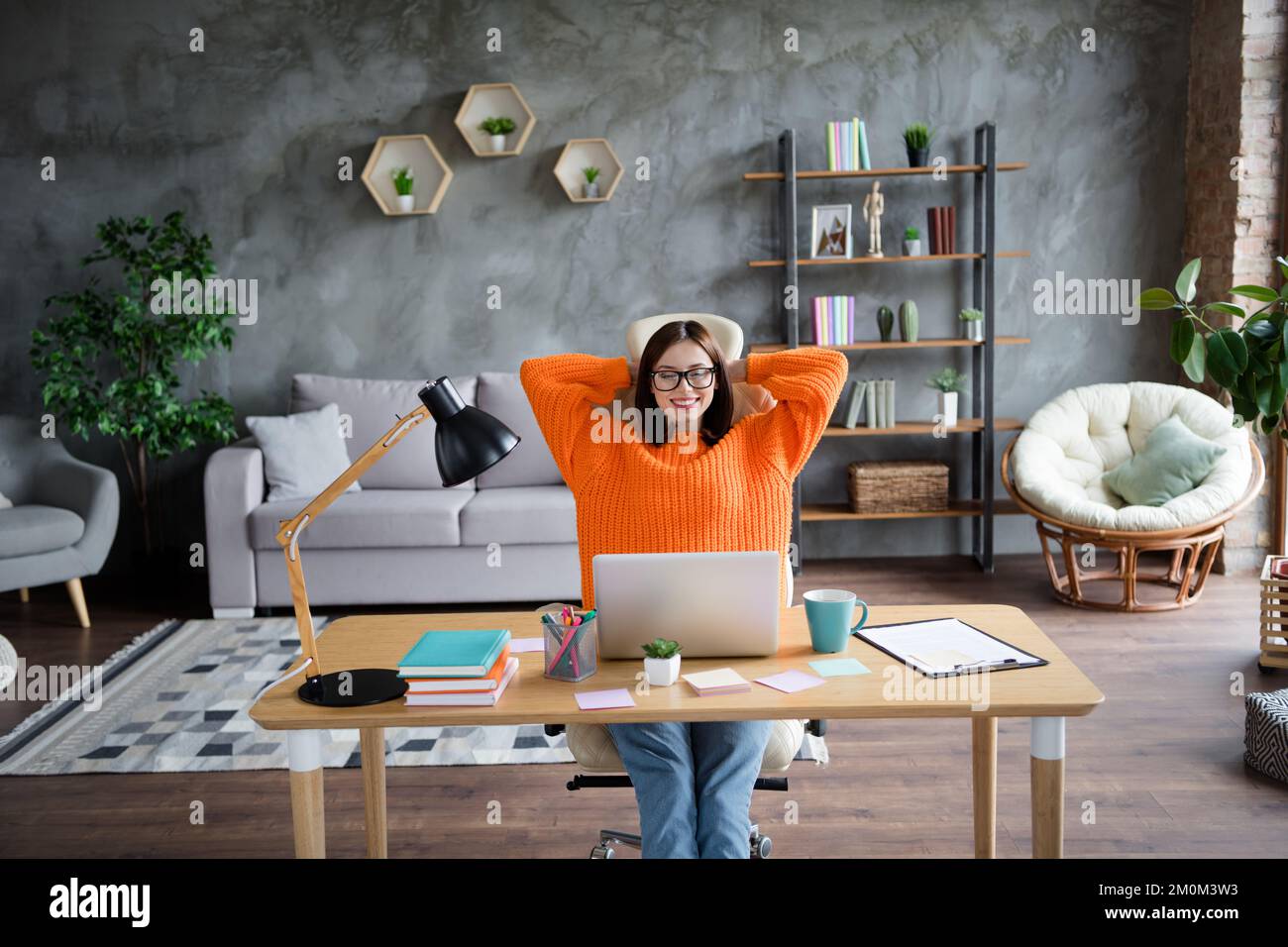 Photo of young happy glad woman relax sit chair table hold arms behind ...