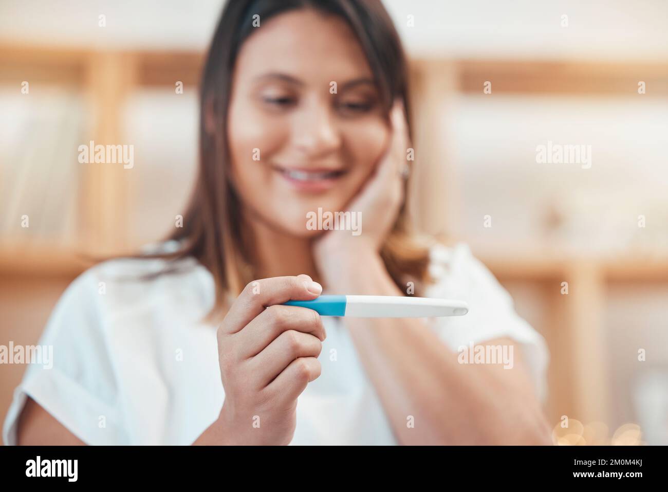 Hand, pregnancy test and results with a surprised woman looking at a ...