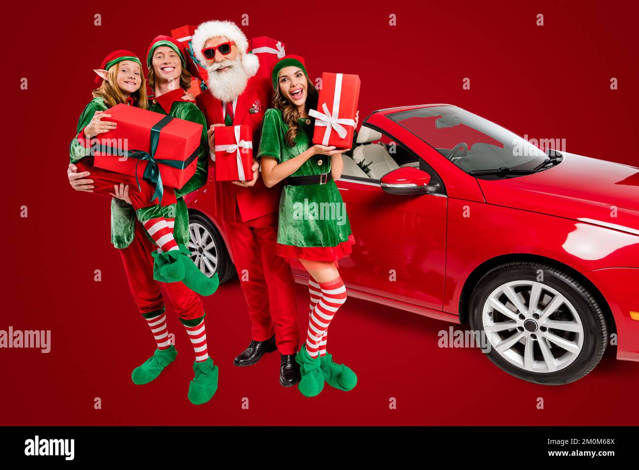 Photo of funny excited santa claus helpers smiling riding car ...