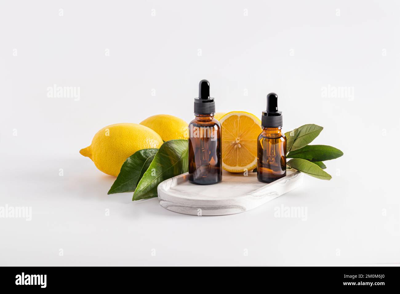 lemon serum or essence, essential cosmetic oil in cosmetic bottles on a ...