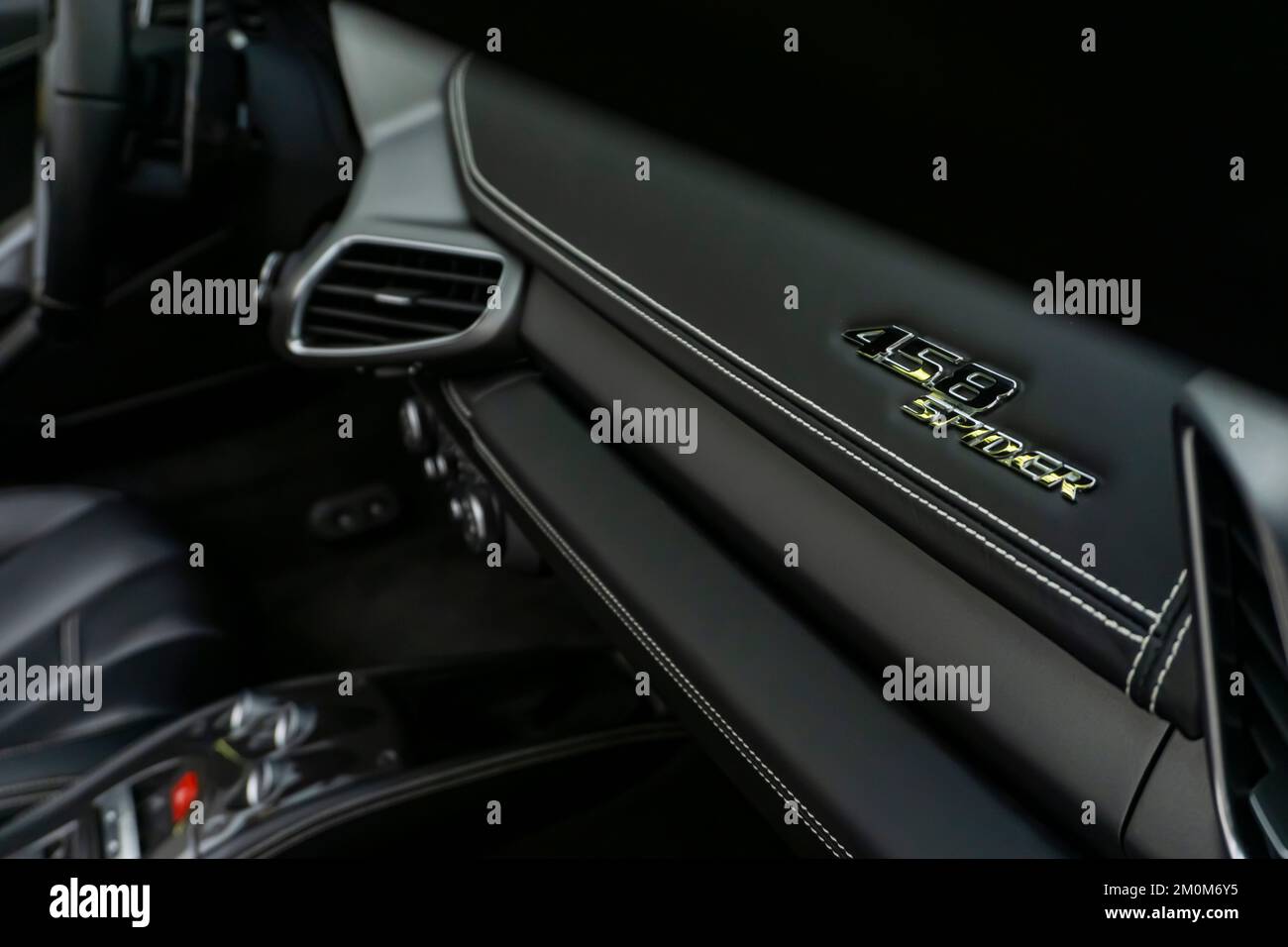 A closeup shot of details on a Ferrari 458 Spider dashboard model badge ...