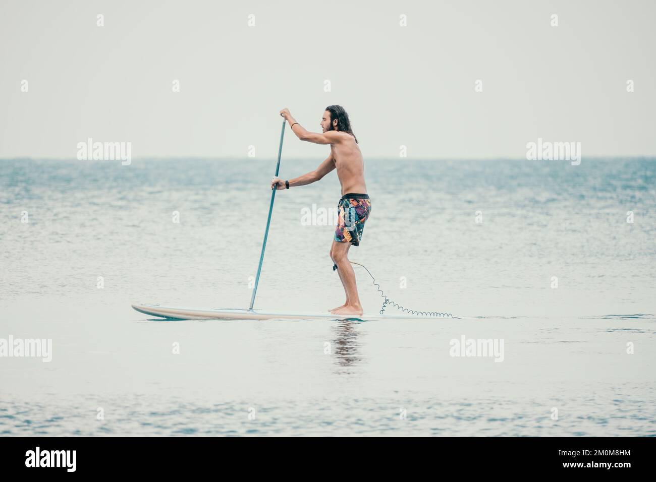 Sea man sup. Asian athlete man swimming in sea and paddleboarding at ...
