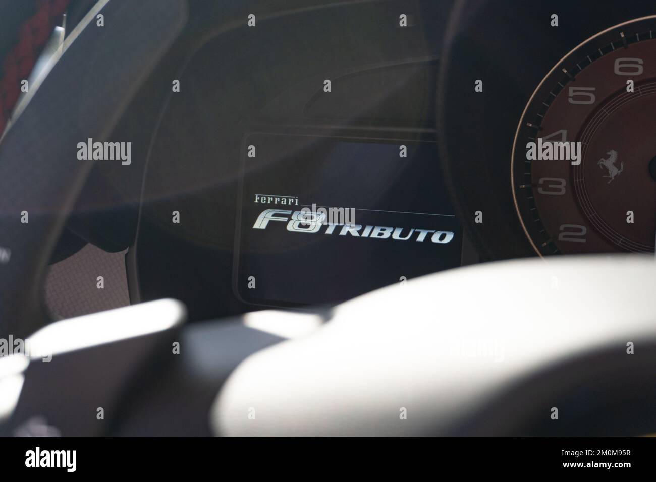 A closeup shot of details on a Ferrari F8 Tributo Gauge cluster logo on ...
