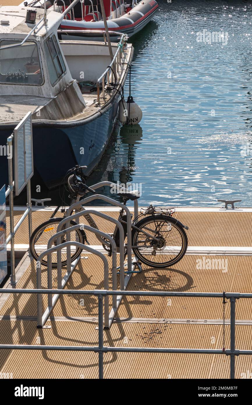 A bicycle parked in a bike rack on a pontoon in Torquay Harbour, Devon ...