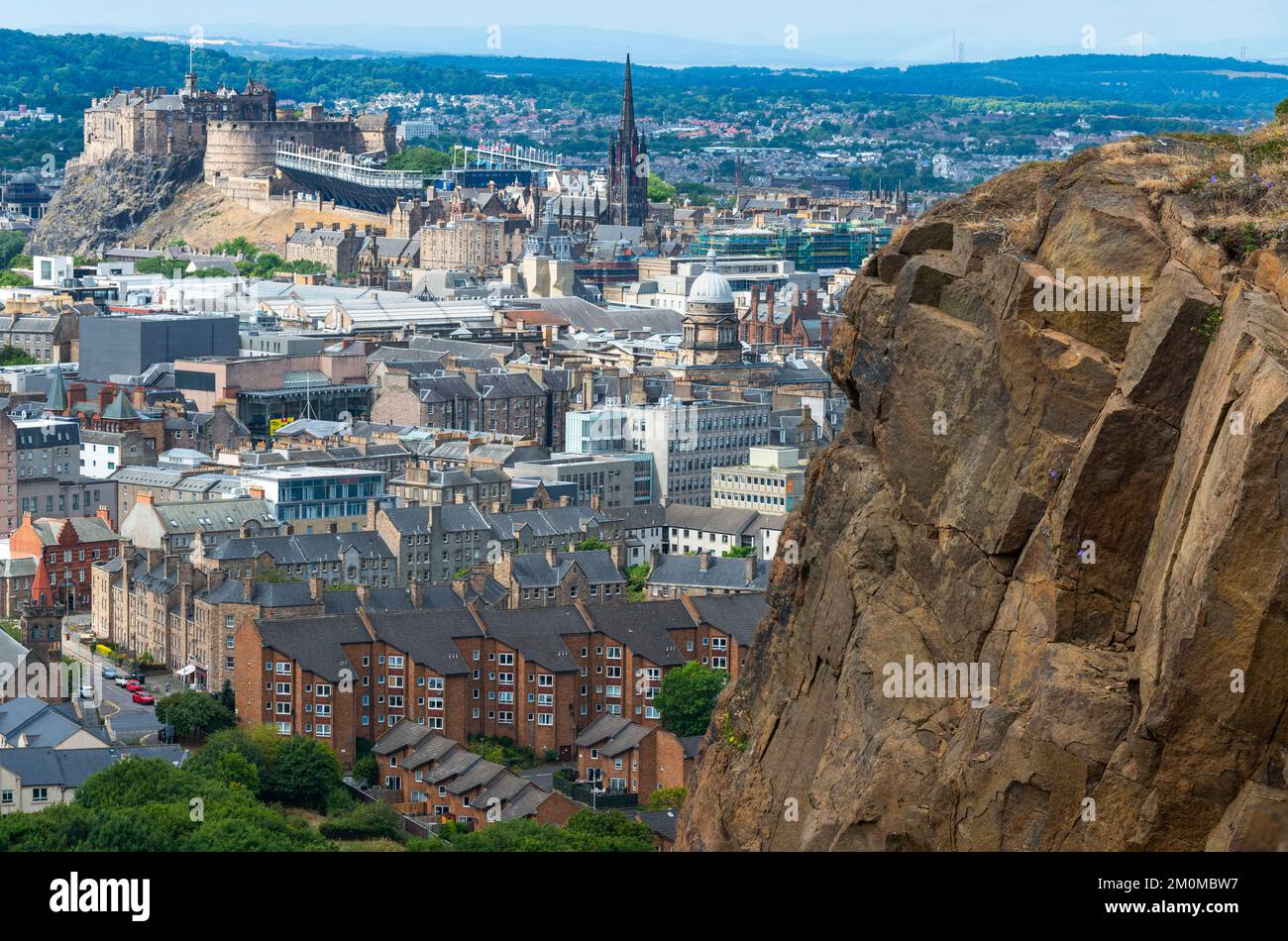 Rocky cliffs in the foreground,dominate the Scotland's capital city ...