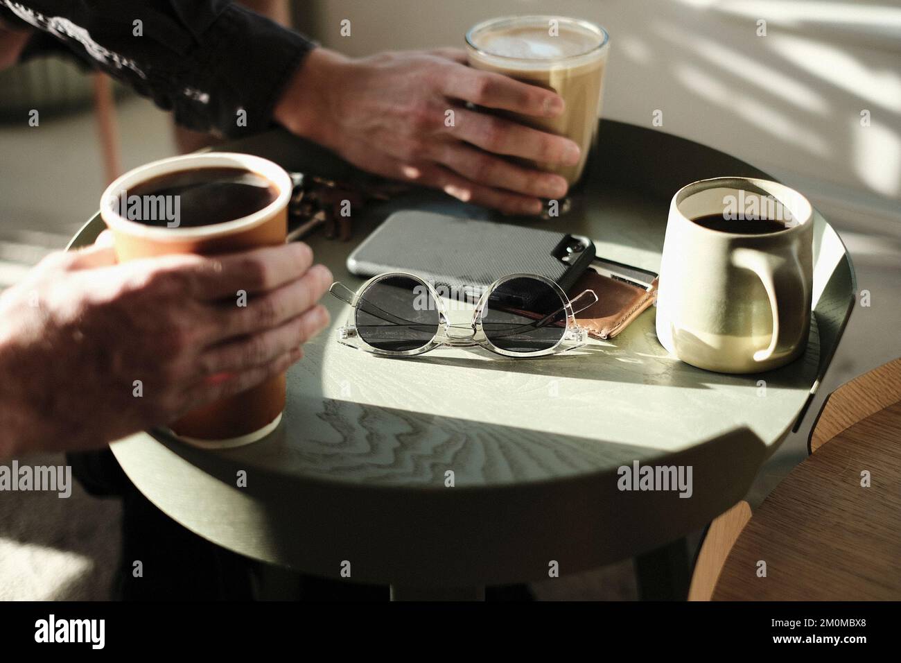 The hands of people grabbing the fresh coffee cups from the table in ...