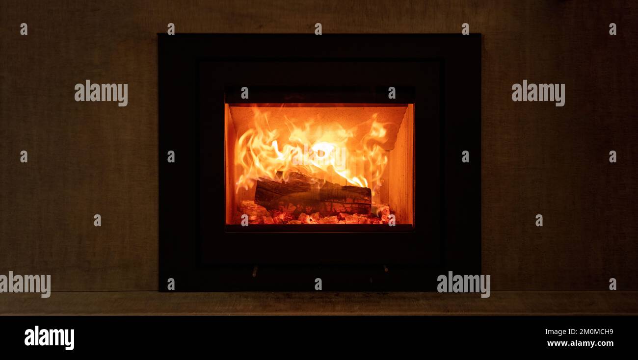 Fire flames and burning wood logs, energy stove fireplace on a wall ...