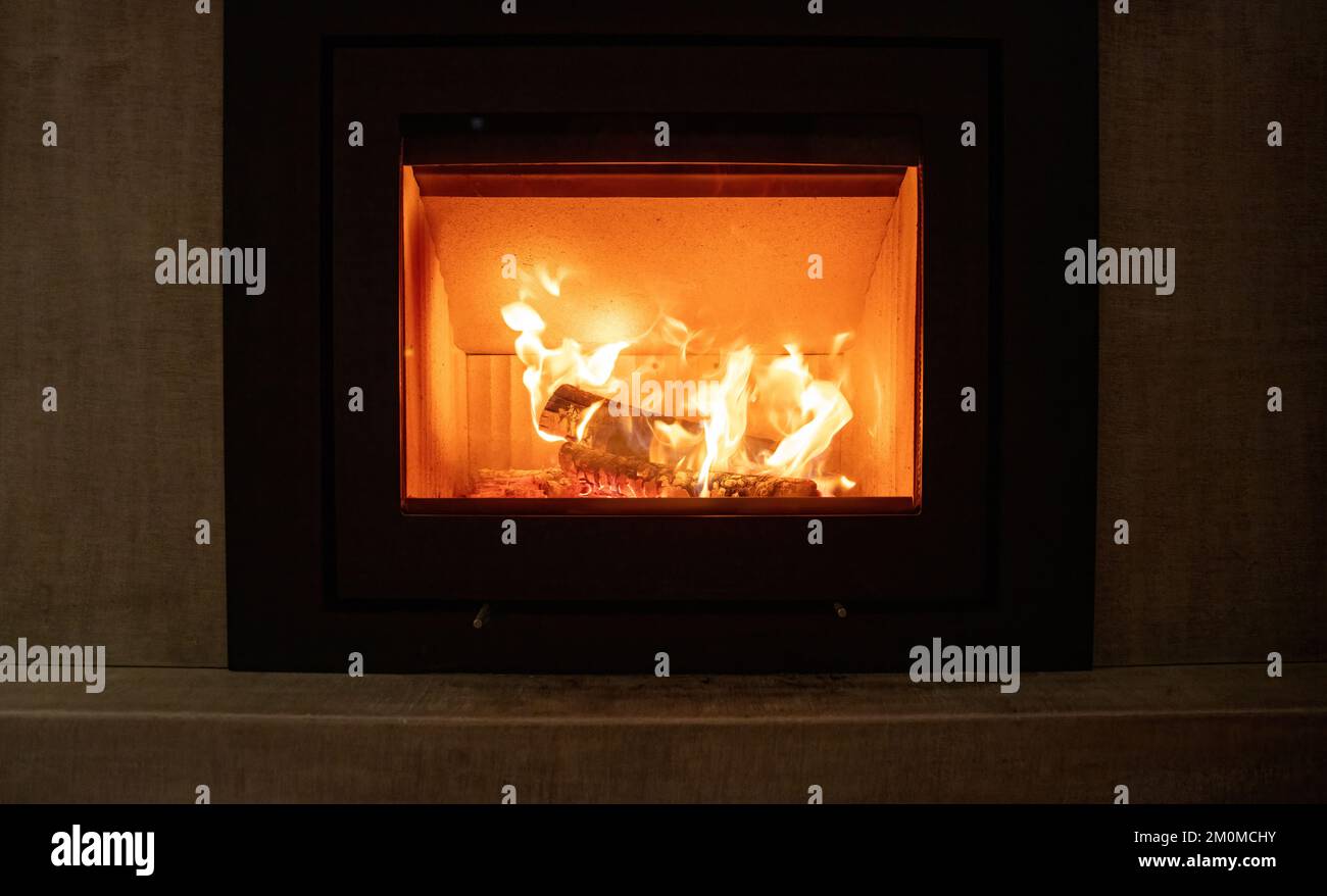 Fire flames and burning wood logs, energy stove fireplace on a wall ...