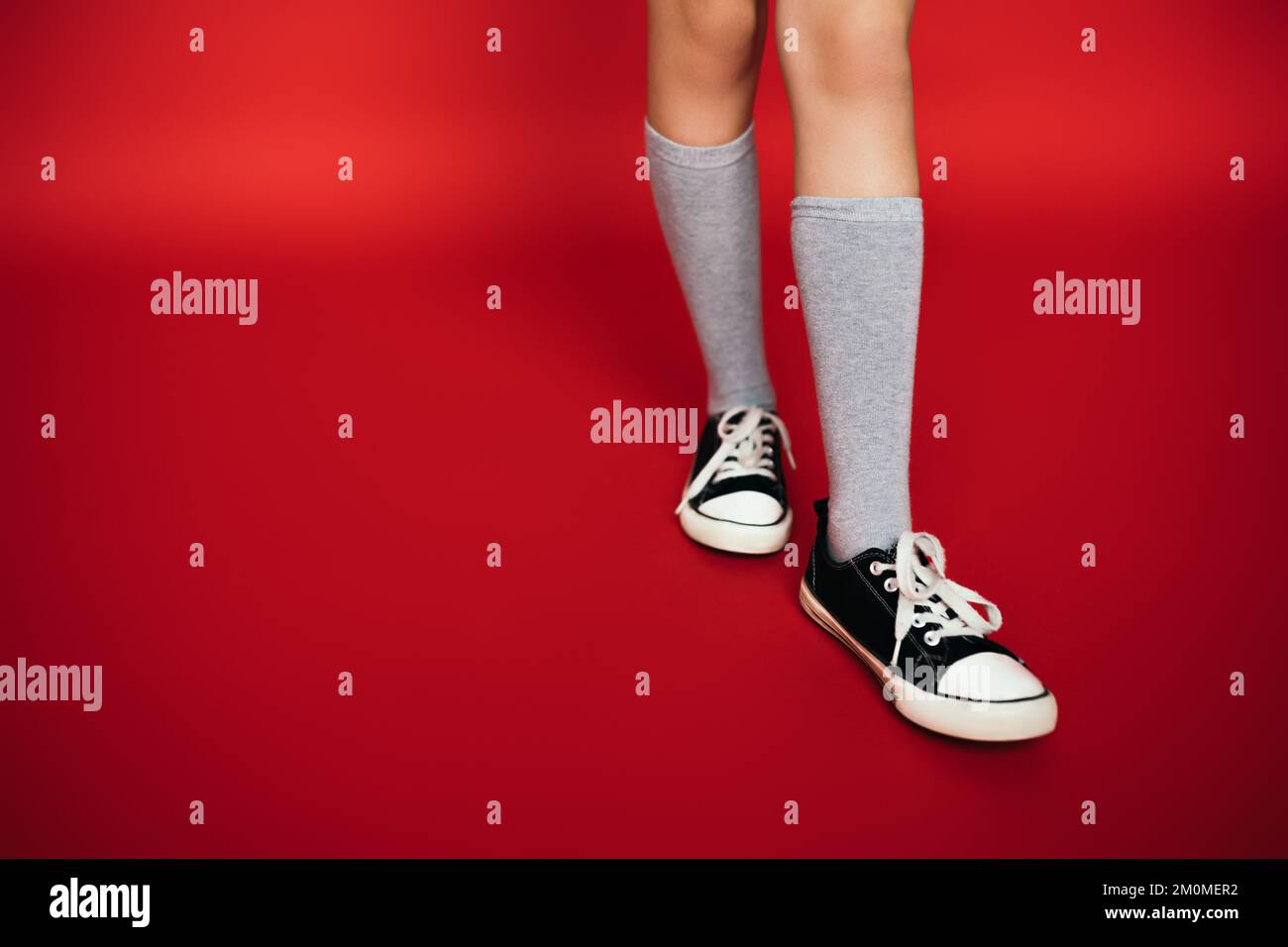 partial view of child in grey knee socks wearing black and white ...