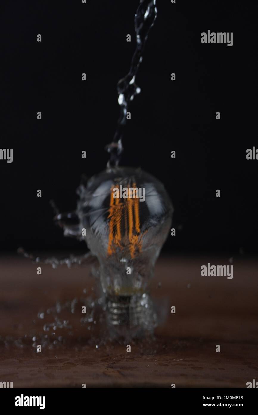 Light bulb made of water splashes on wood surface Stock Photo - Alamy