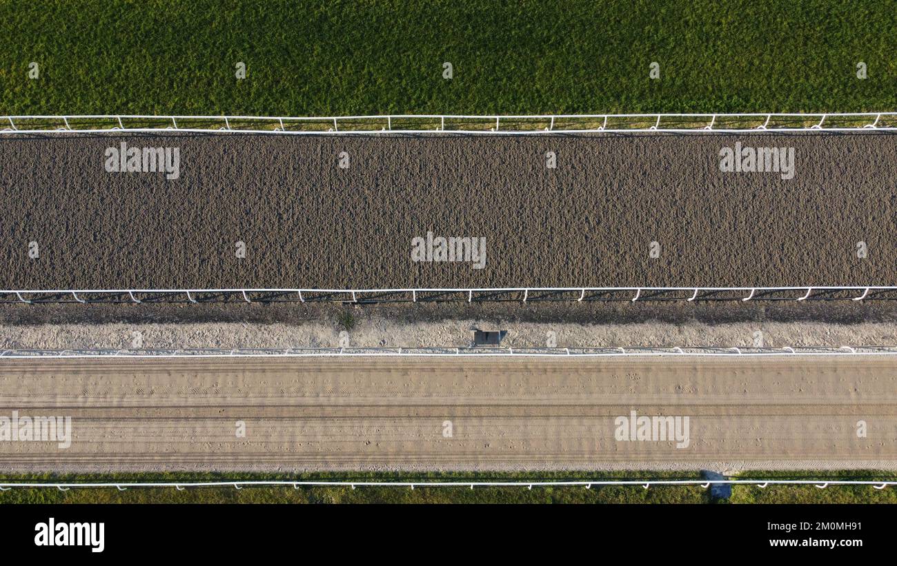 A top view of a fenced gray walkway and green grass, aerial texture ...