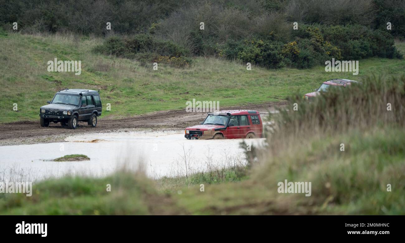 three land rover discovery 4x4 off-road vehicles being driven through ...
