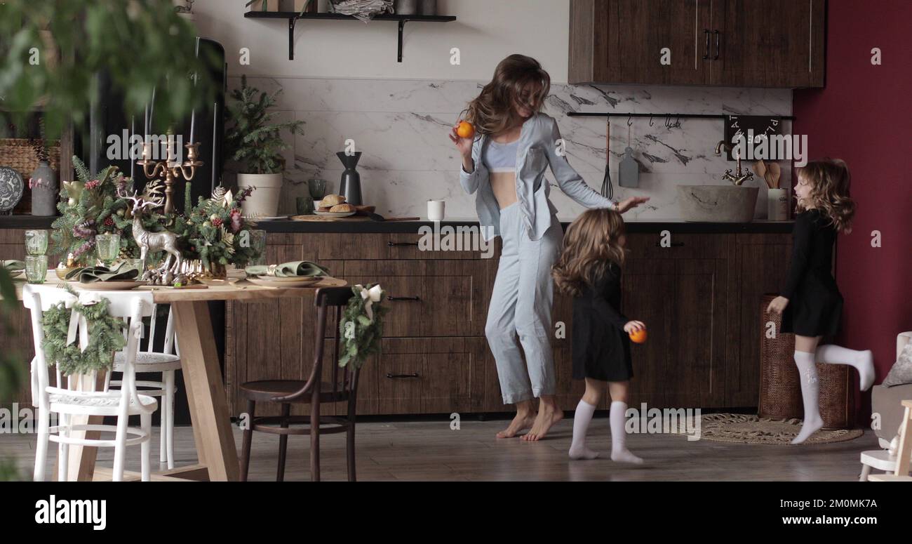 Dancing young mother, daughters having fun festive holidays together on ...
