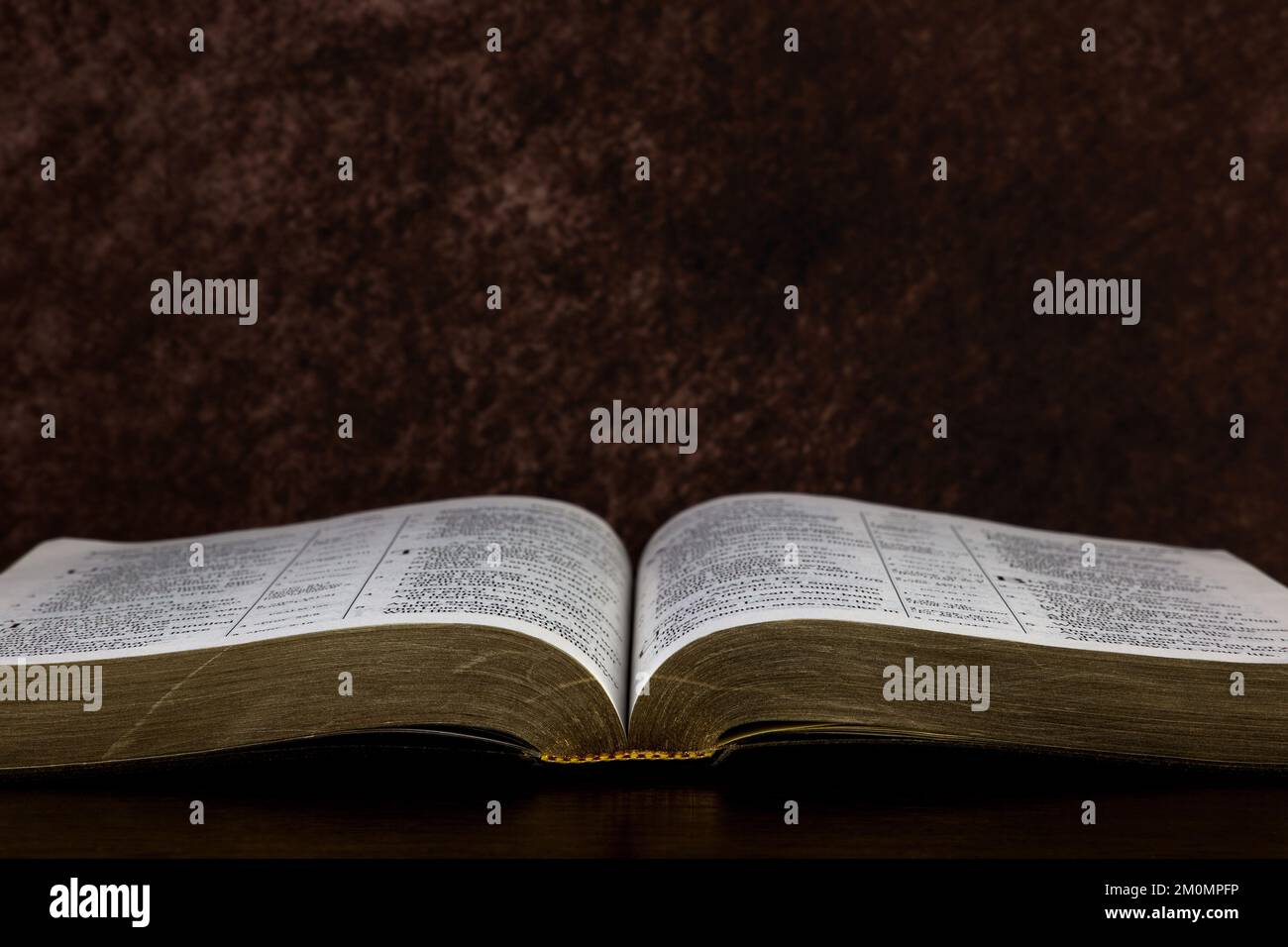 Open christian bible lying on a polished wooden shelf Stock Photo - Alamy