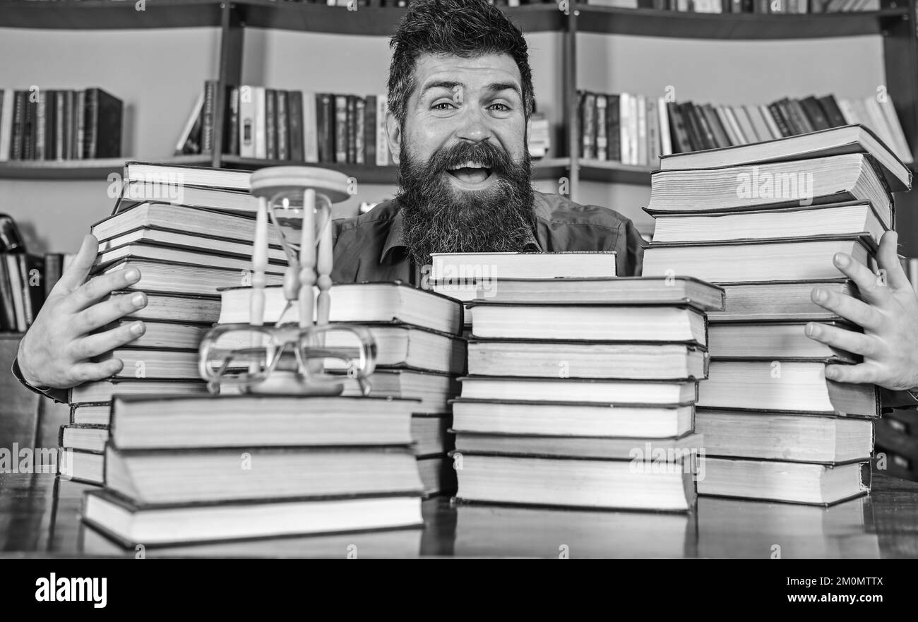 Man on happy face between piles of books, while studying in library ...