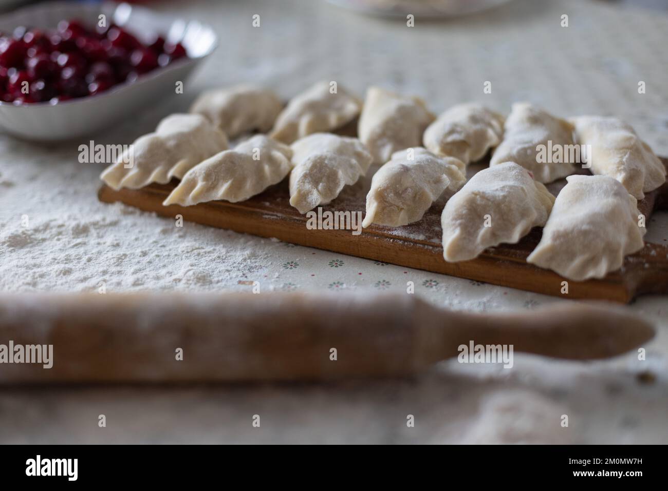 Homemade raw dumplings with cherries. Cooking at home. Selective focus ...
