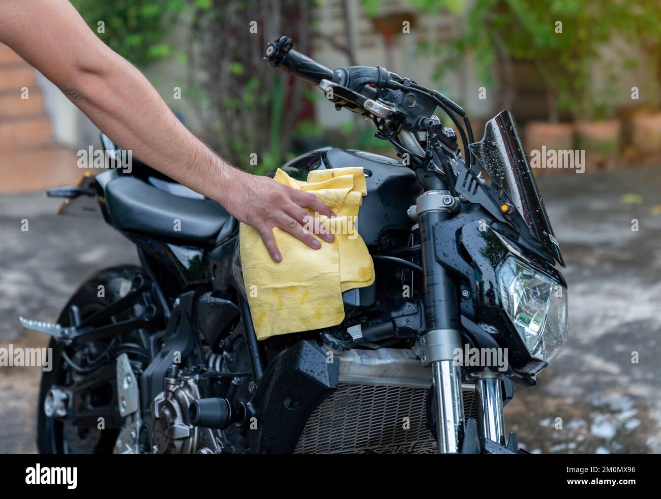 Biker man cleaning motorcycle , Polished on fuel tank in laundry area ...