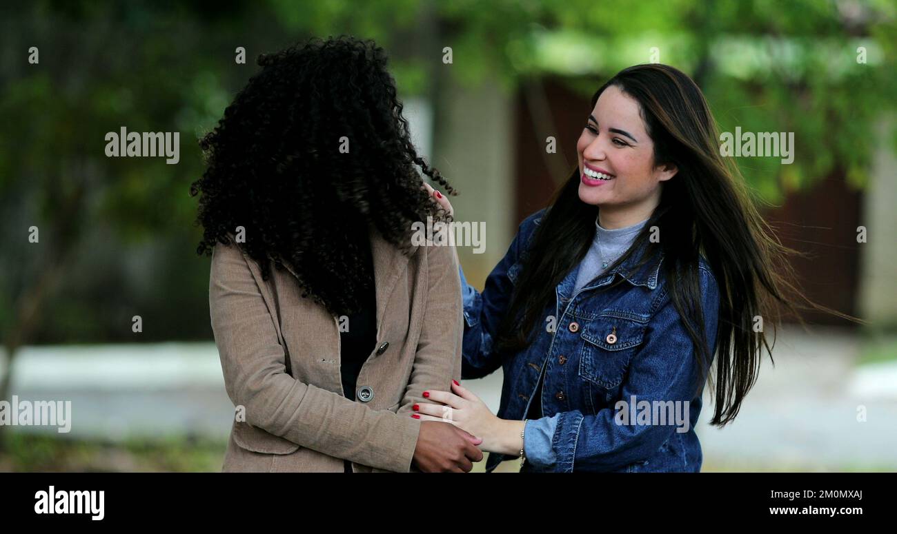 Two diverse friends laughing and smiling together outside. Two ...