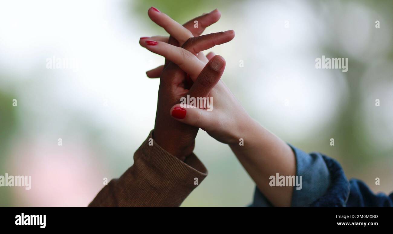 Two diverse hands joining force in unity, two people uniting hand ...