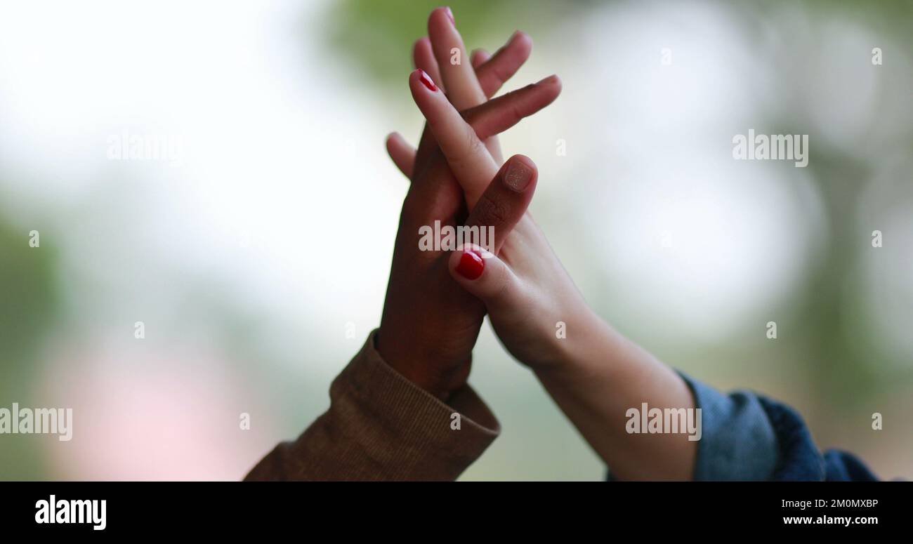 Two diverse hands joining force in unity, two people uniting hand ...