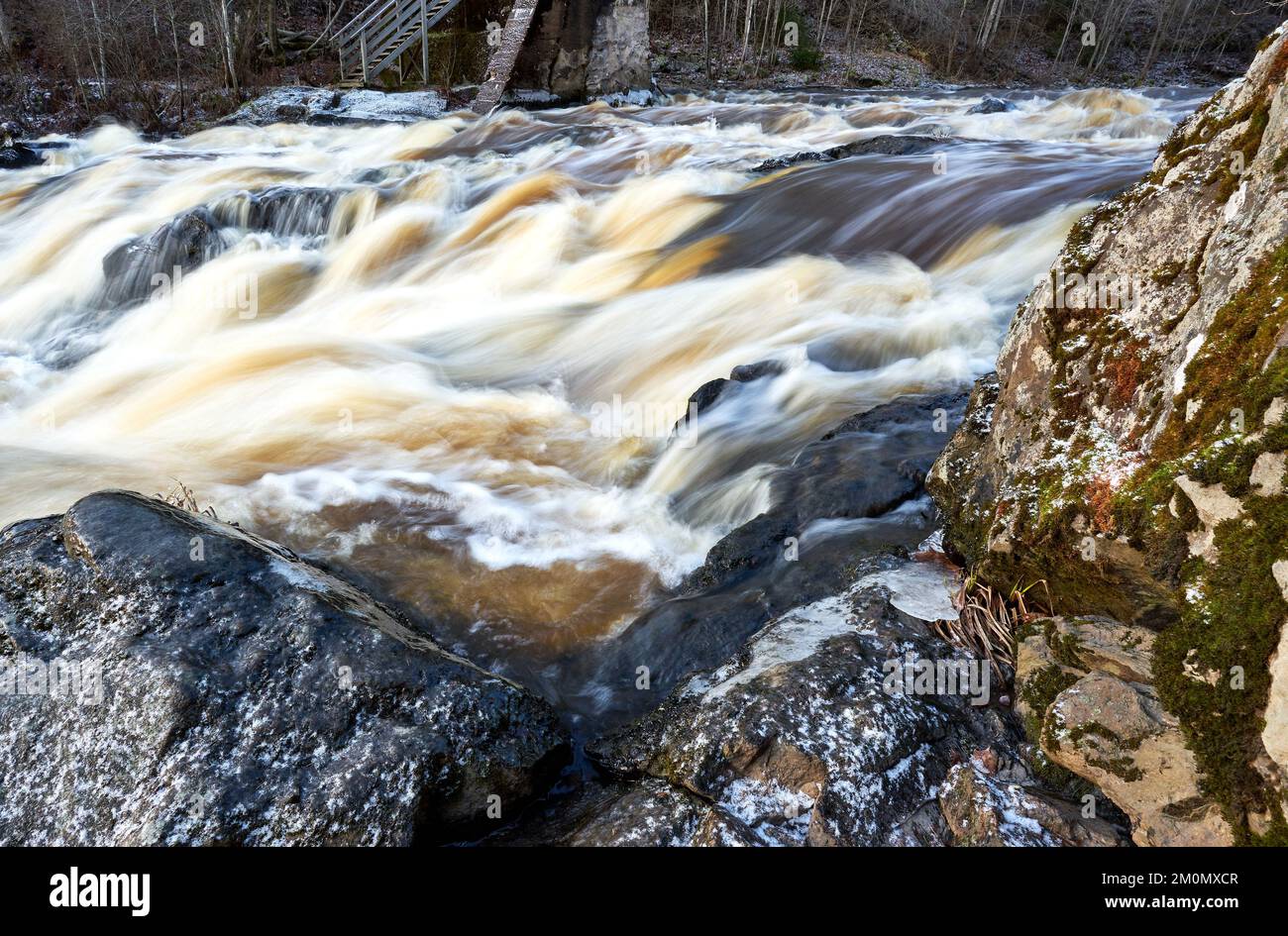 A closeup of the harsh flow of a rocky river with a silky water effect ...
