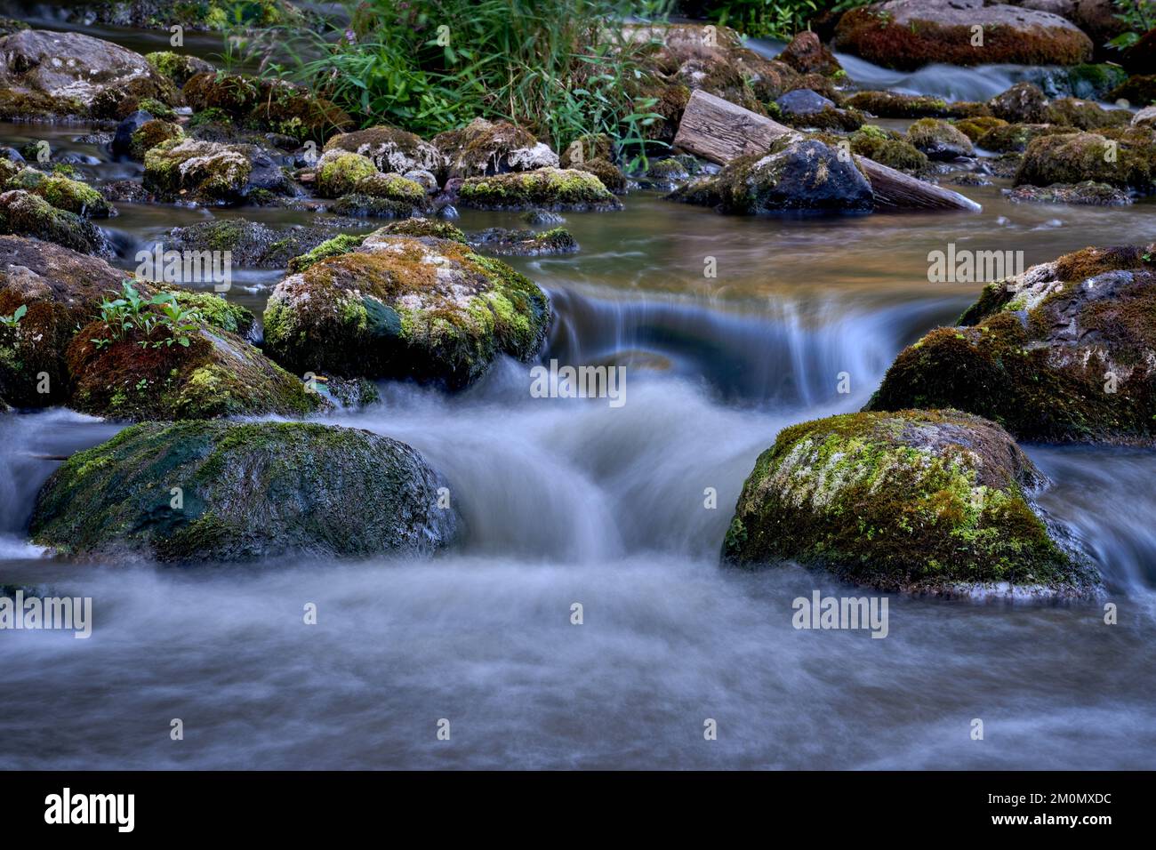 A scenic shot of the flow of a rocky river with a silky water effect ...