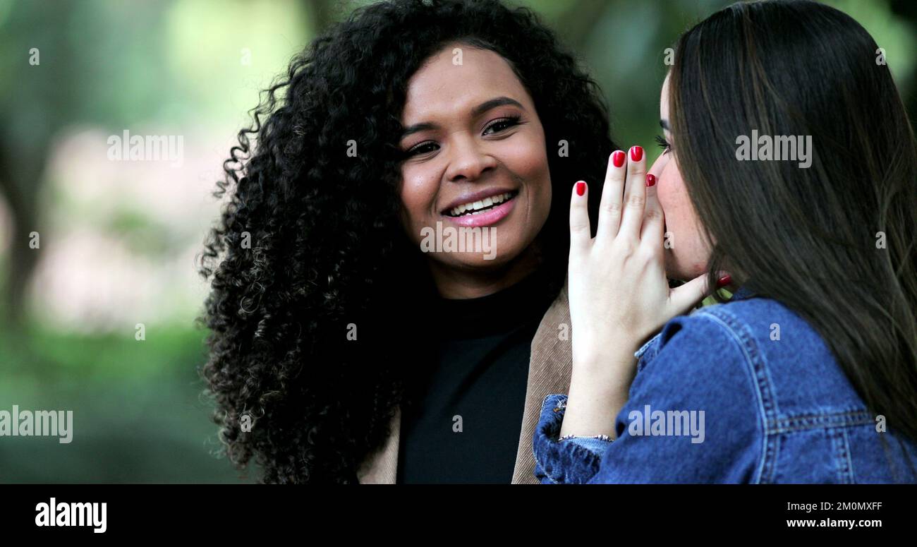 Two girls telling gossip secret. Woman real life laugh reaction Stock ...