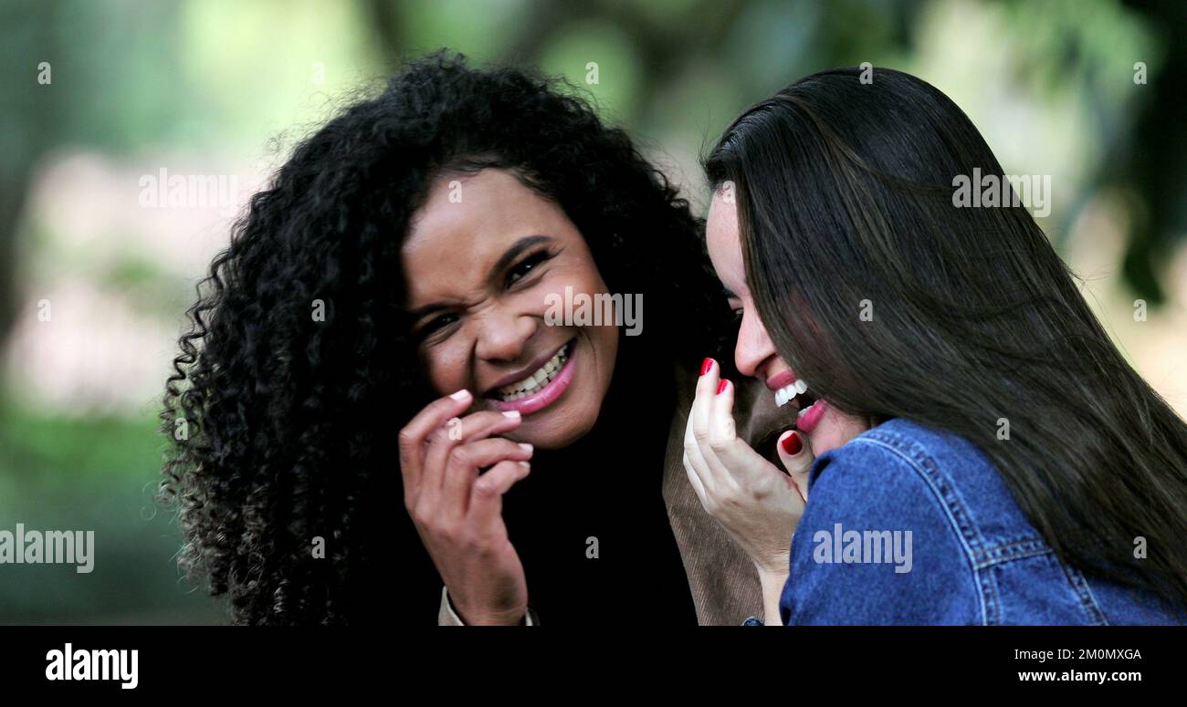 Two girls telling gossip secret. Woman real life laugh reaction Stock ...