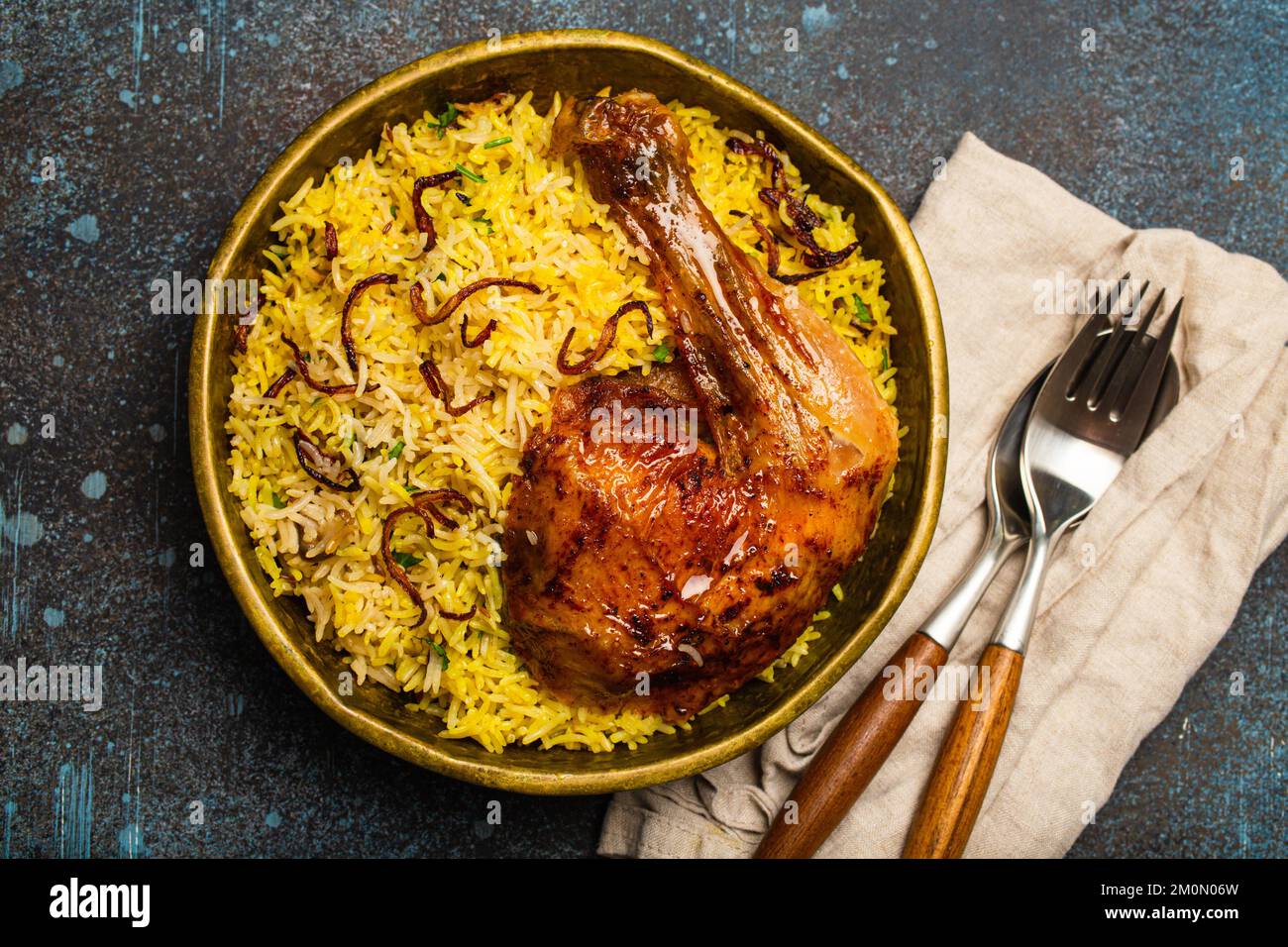 Indian dish Biryani chicken with basmati rice in metal brass old bowl ...