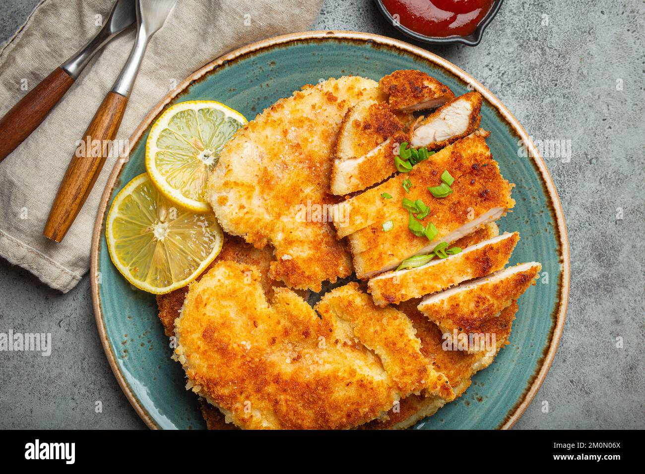 Crispy panko breaded fried chicken fillet with green salad and lemon ...